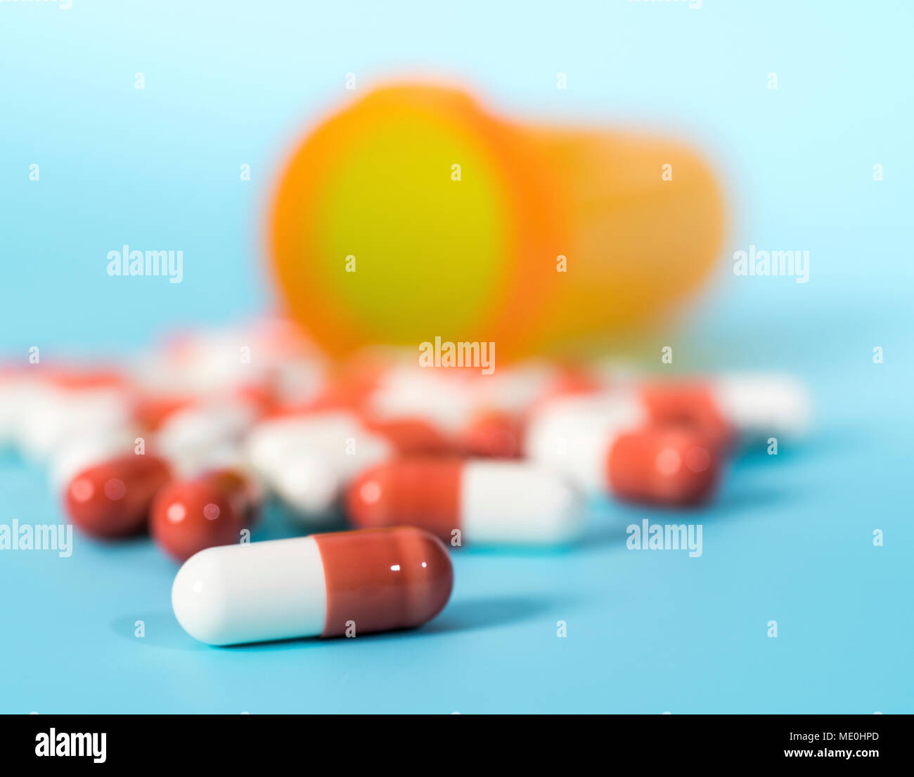 Drug capsules spilling from bottle Stock Photo - Alamy