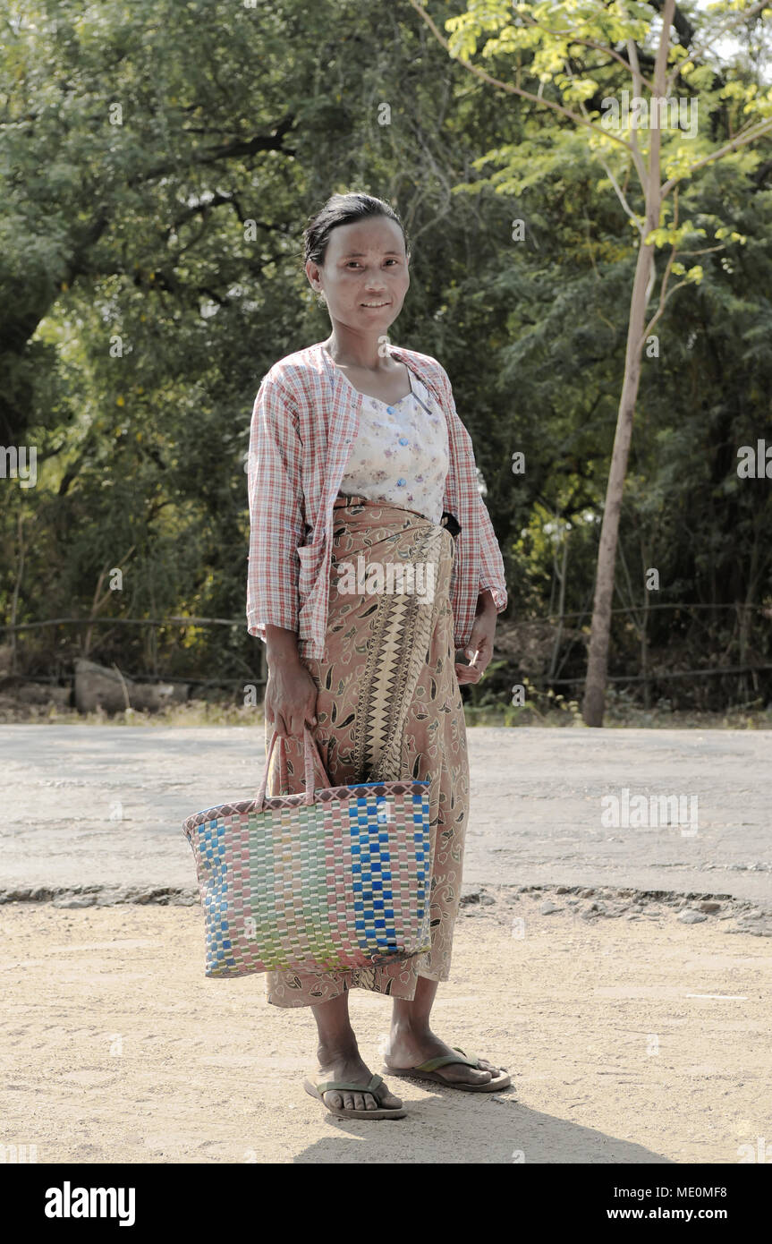 A woman standing with a woven bag going to market; Bagan, Myanmar Stock ...