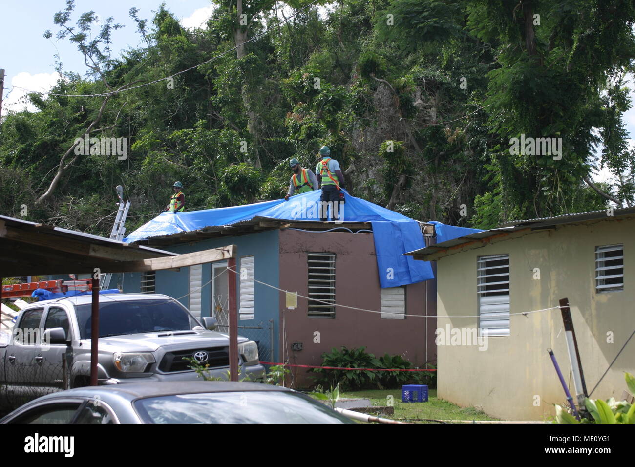 An Operation Blue Roof crew installs the reinforced plastic sheeting on ...