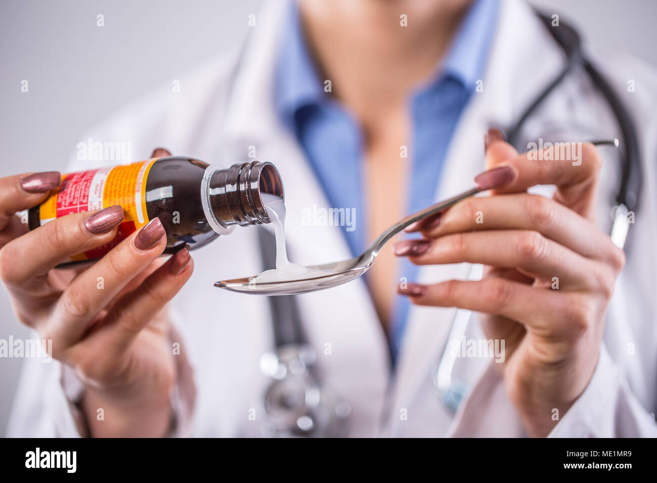 Hands of young woman doctor pouring medicinal syrup on spoon Stock ...