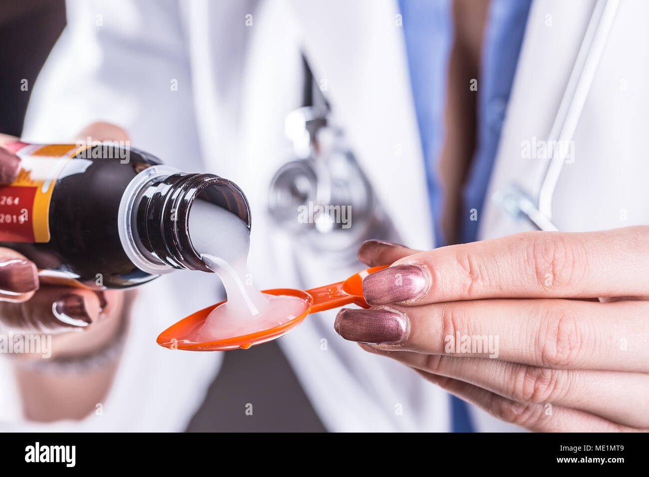 Hands of young woman doctor pouring medicinal syrup on spoon Stock ...