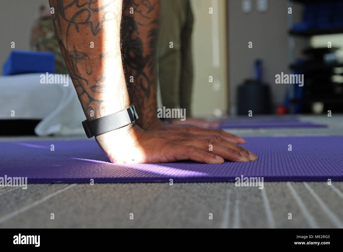 A yoga therapy patient brings his hands to the mat at the Intrepid ...