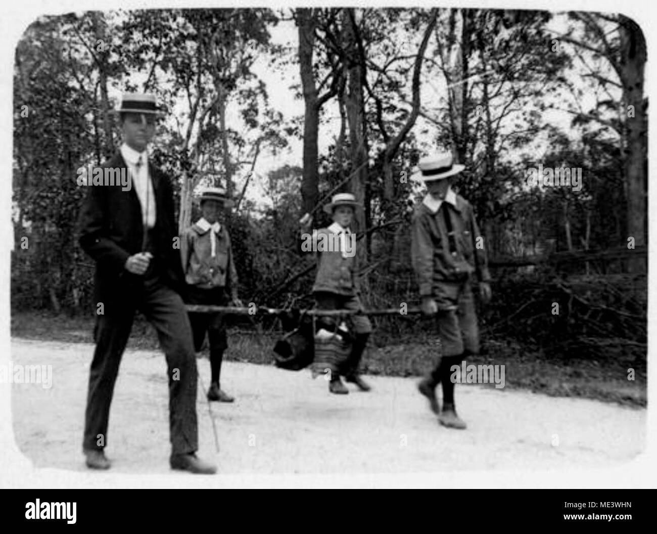 Schoolboys carrying their bags on a stick Stock Photo - Alamy