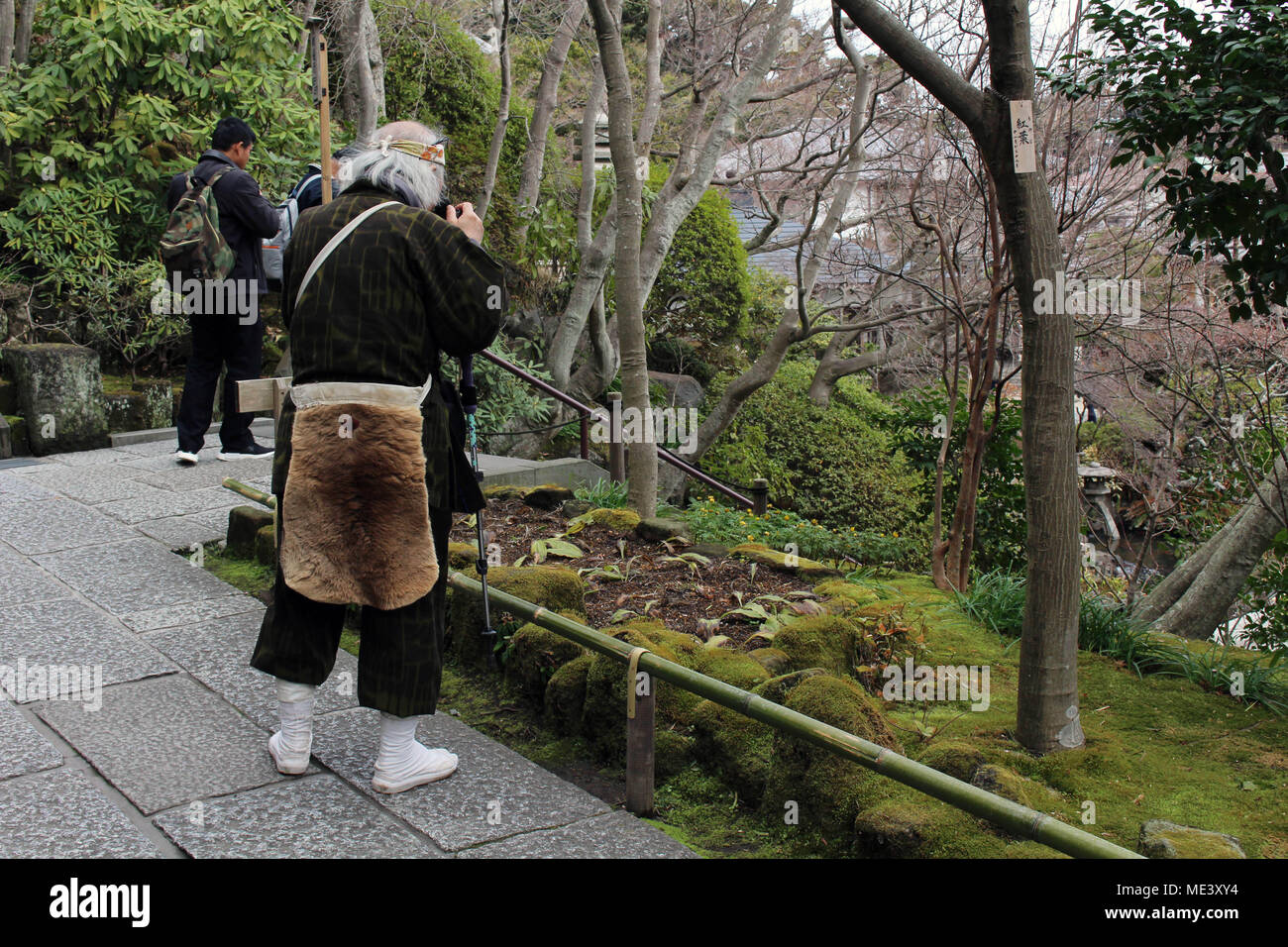 A traditional Japanese pilgrim (?) taking photos at Hasedera Temple ...