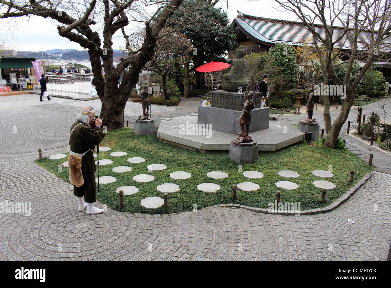 A traditional Japanese pilgrim (?) taking photos at Hasedera Temple ...