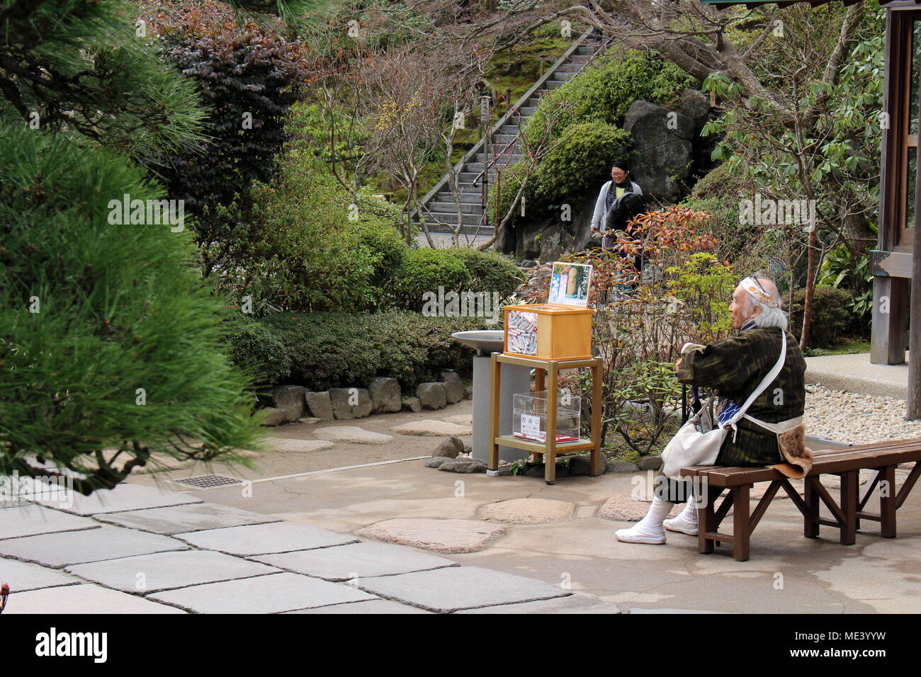 A traditional Japanese pilgrim (?) taking photos at Hasedera Temple ...