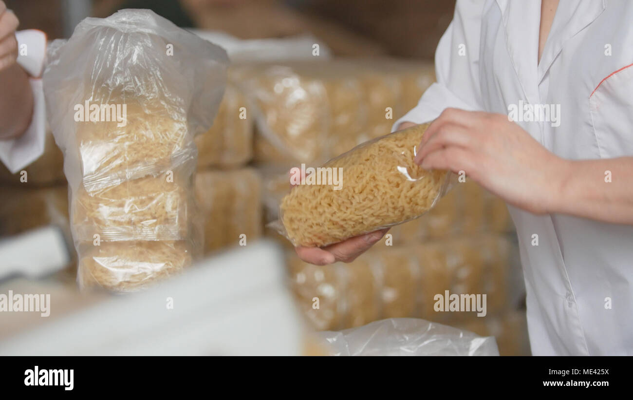 Workers packaging raw macaroni from the production line in a pasta ...
