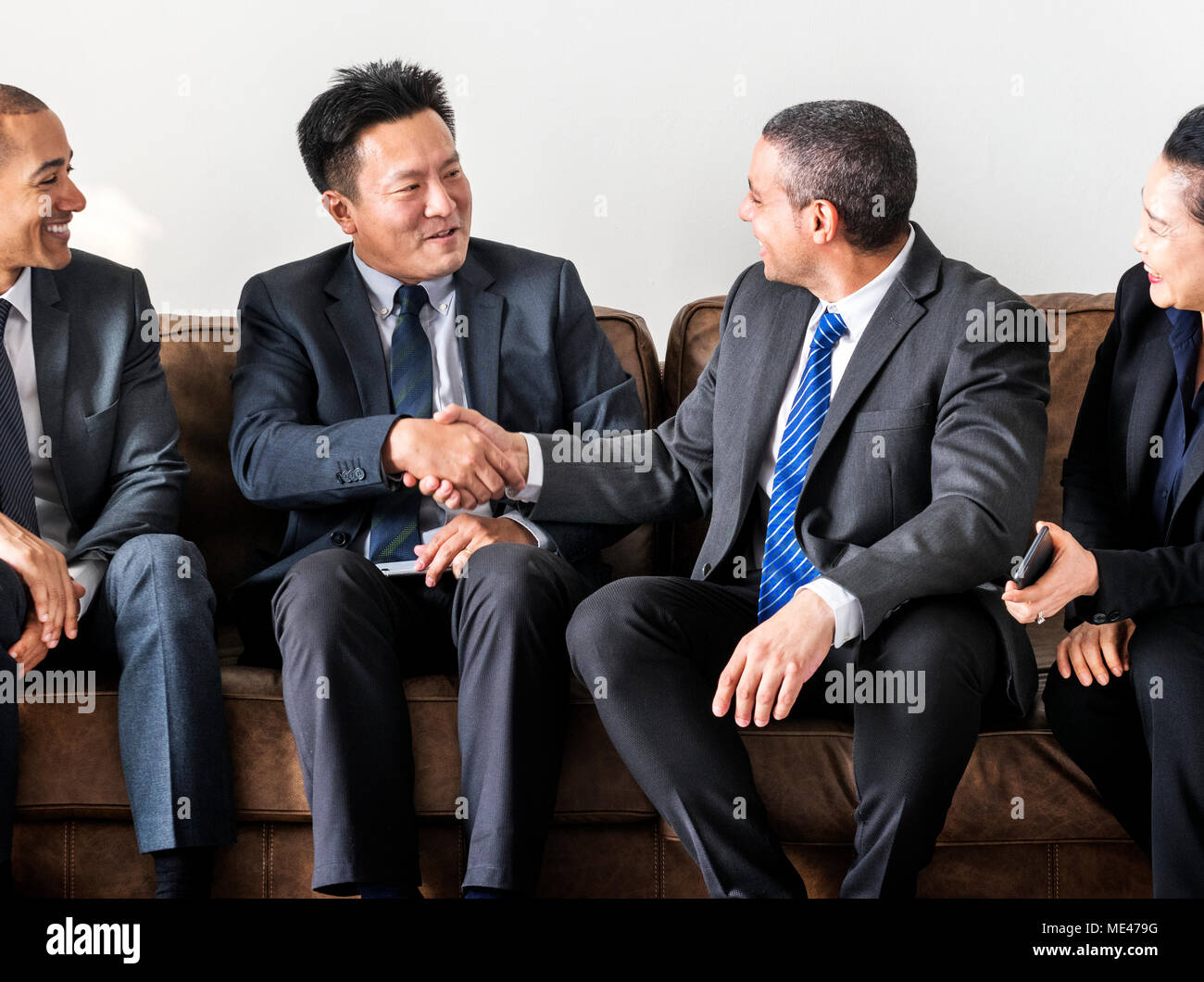 Business people sitting together on couch Stock Photo - Alamy