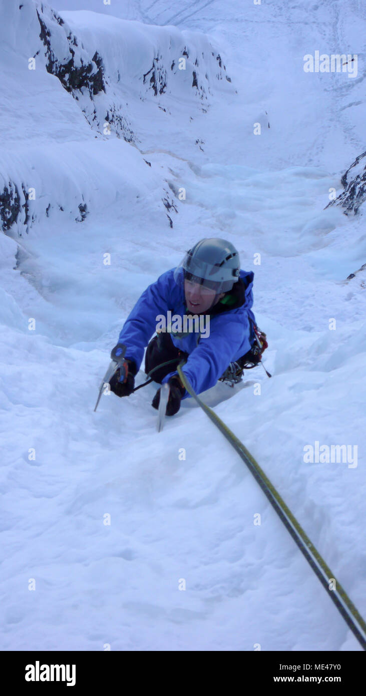 male ice climber on a steep icefall in the Swiss Alps near Davos Stock ...