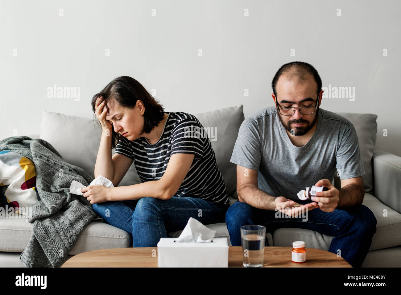 Couple sick at home on the sofa Stock Photo - Alamy