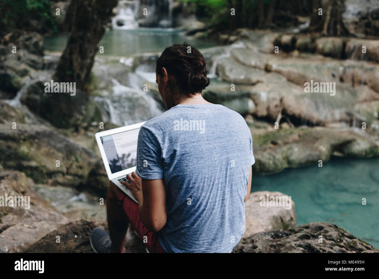 White man using computer laptop at waterfall Stock Photo - Alamy
