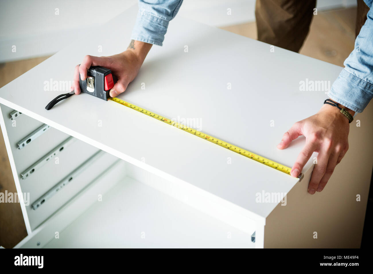 Man measuring the cabinet Stock Photo - Alamy