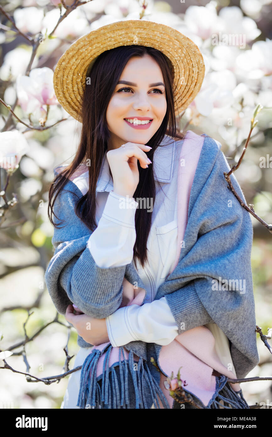 Pensive beautiful girl in straw hat looking up smiling holding touching ...