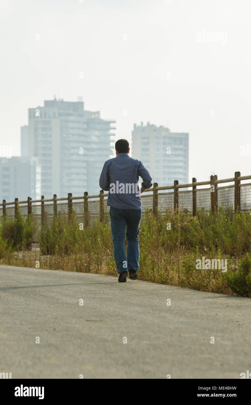 Rear view of a man running away Stock Photo - Alamy