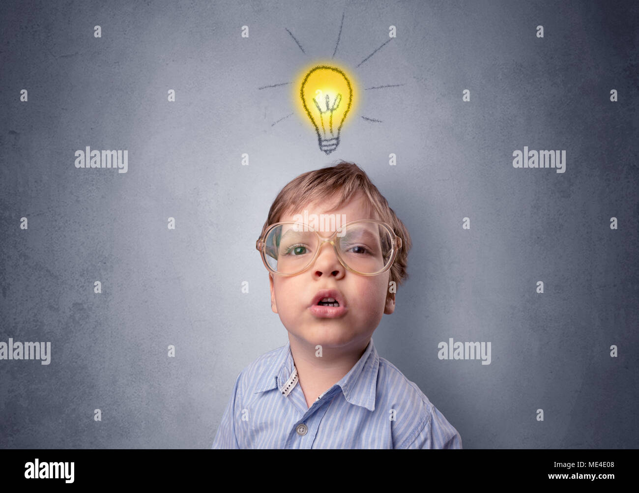 Adorable little kid mull over in front of a grey wall with idea symbol ...