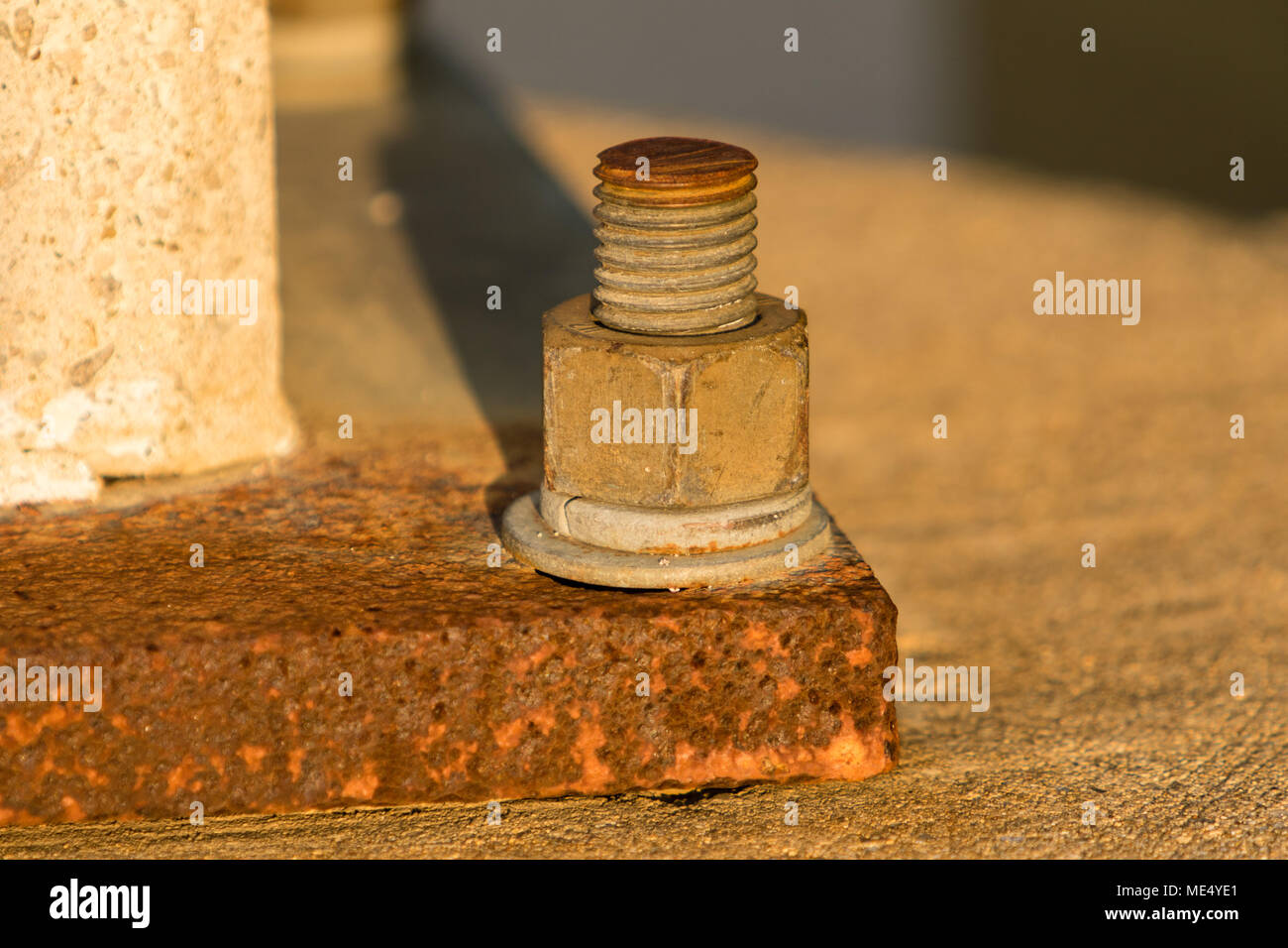 a really big bolt on rusty platform at sunset Stock Photo - Alamy