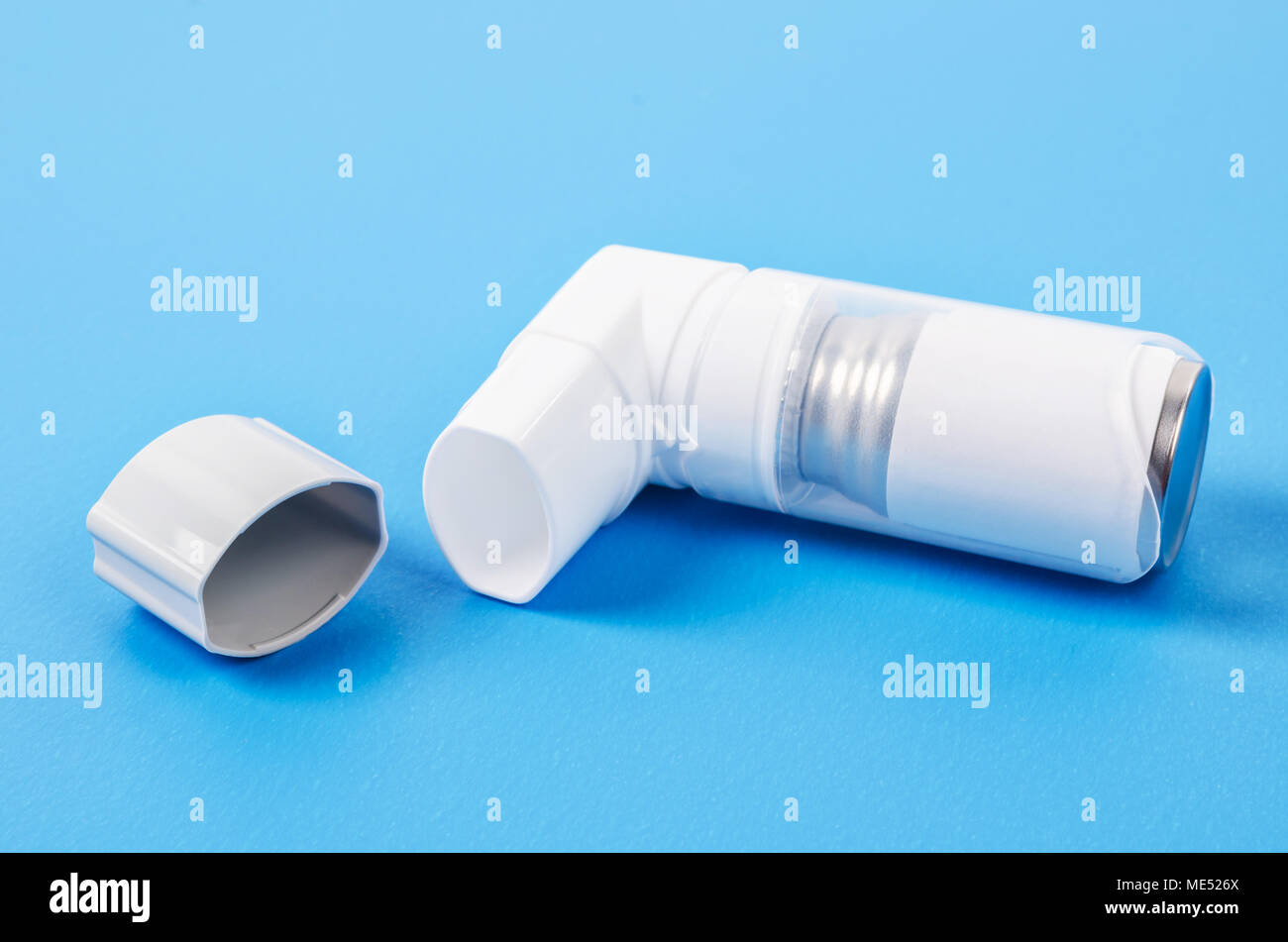 Asthma inhaler on blue background Stock Photo - Alamy