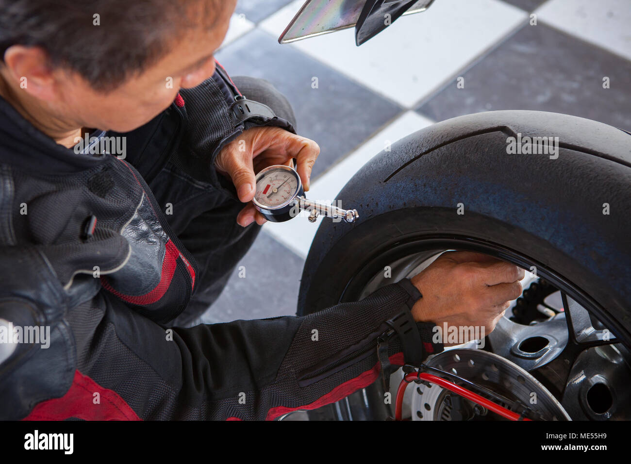biker checking air pressure in rear wheel of big motorcycle Stock Photo ...