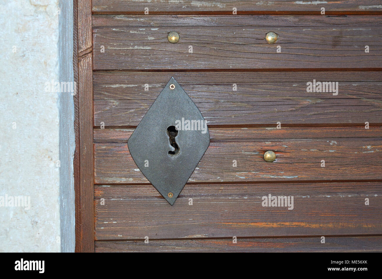 Rustic keyhole on a heavy brown wooden door Stock Photo - Alamy