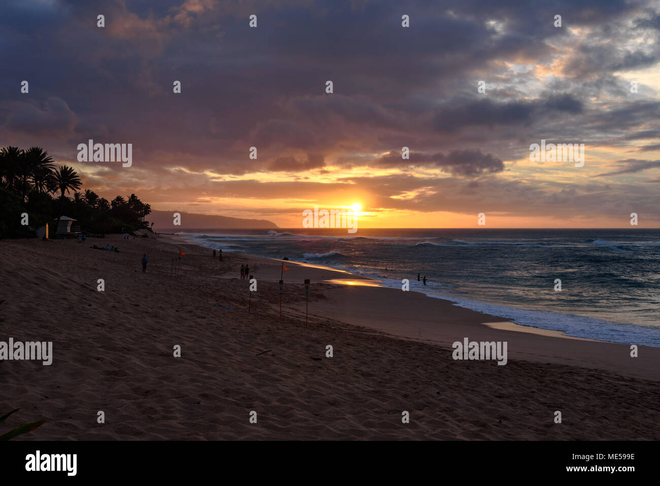 Waves crashing on the beach as the sun goes down as Sunset Beach Park ...