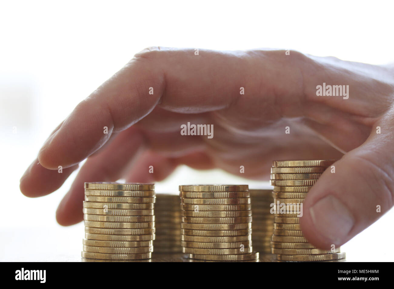 Love of money - Greedy hand grabbing or reaching out for pile of golden ...