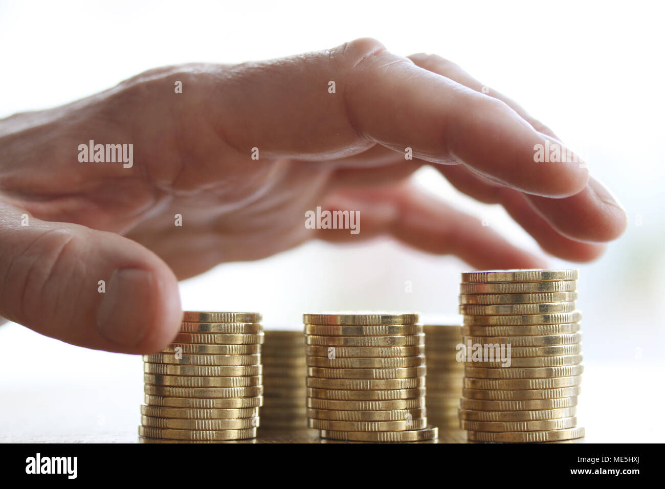 Love of money - Greedy hand grabbing or reaching out for pile of golden ...