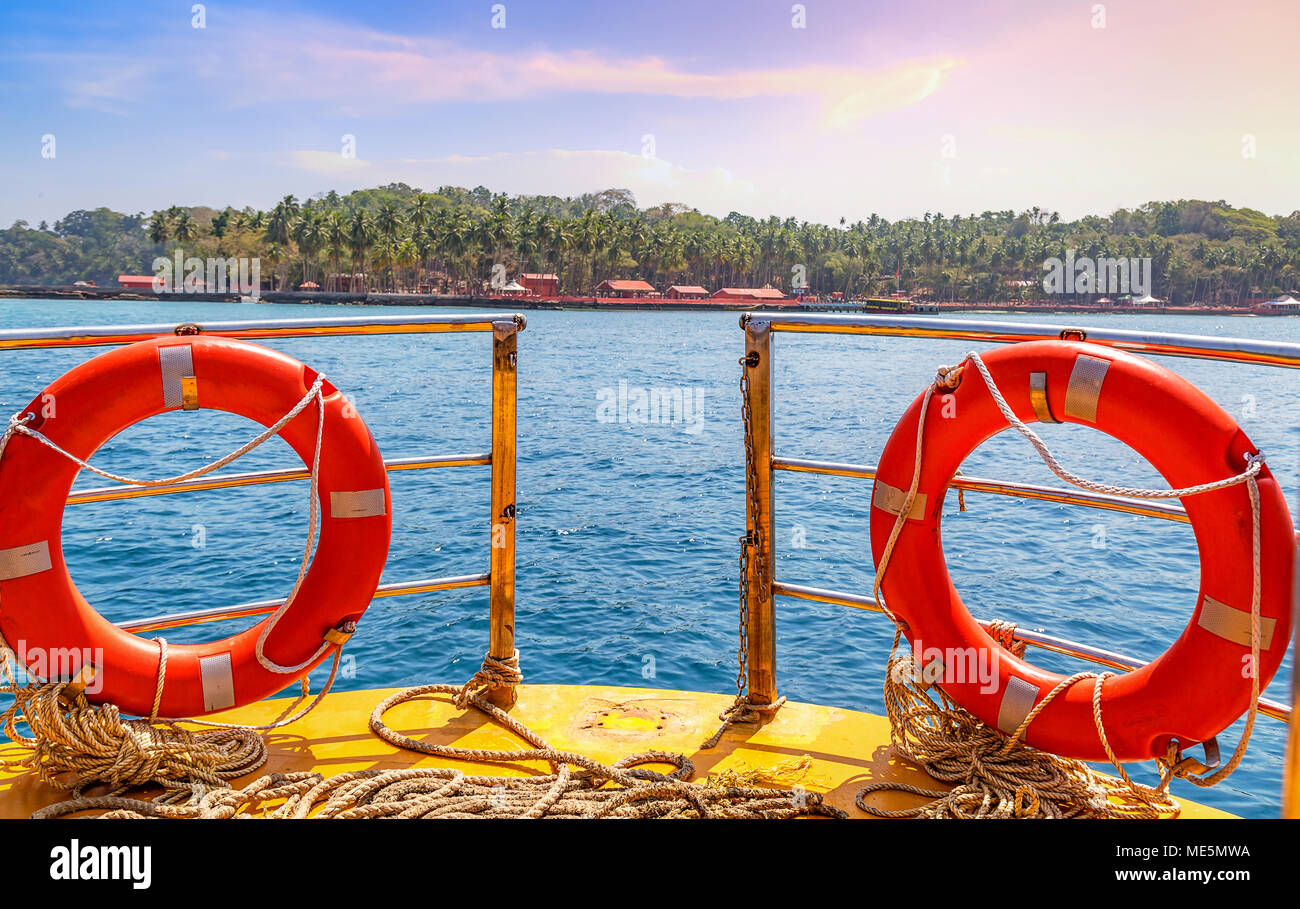 Steel railings and lifebuoy at the front end of a tourist speed boat ...