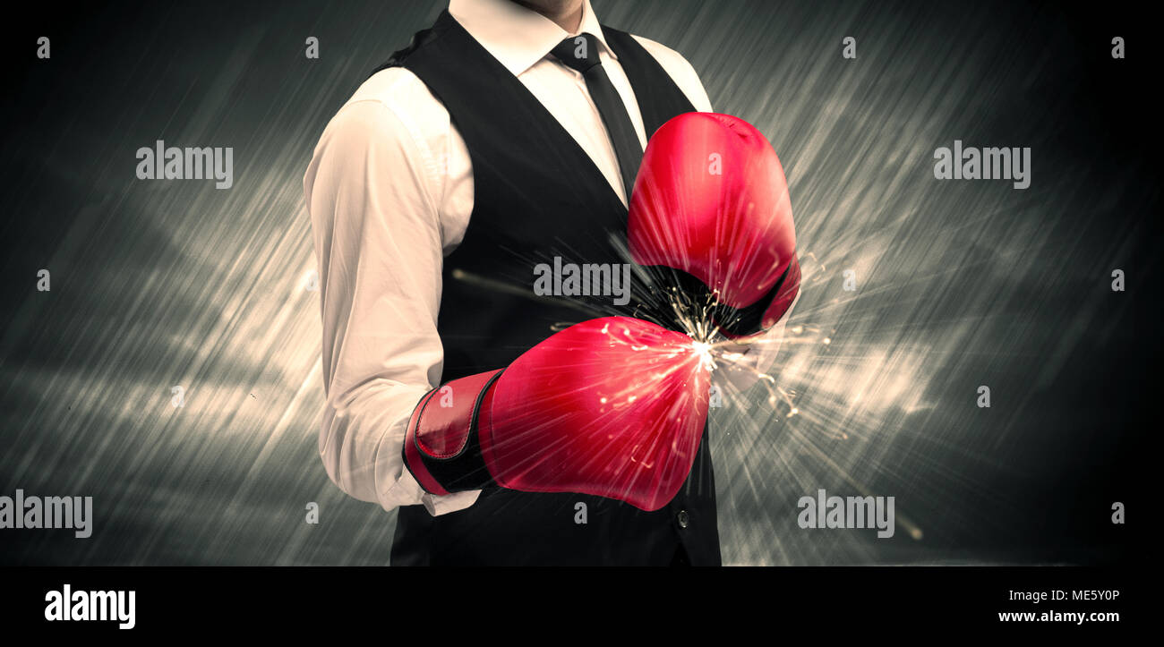 An elegant businessman dressed in suit clashing the boxing gloves on ...