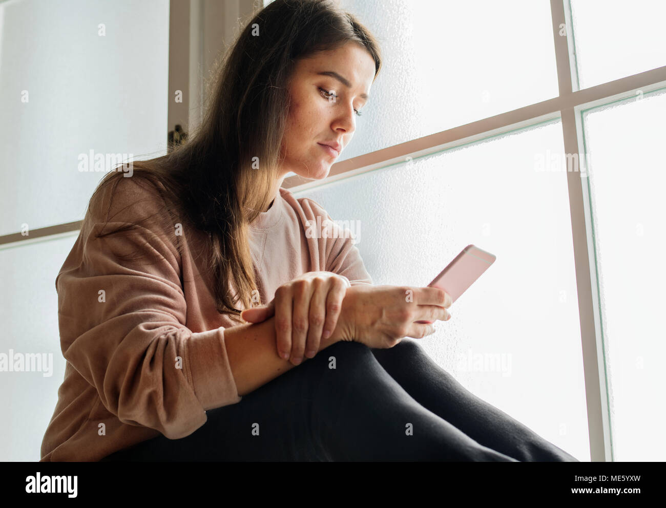 Serious and distressed woman using a smartphone Stock Photo - Alamy