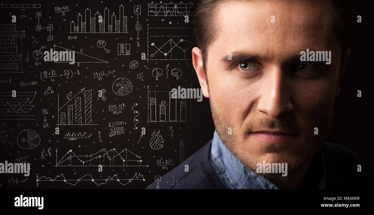 Portrait of a young businessman with charts and graphs scribbled next ...