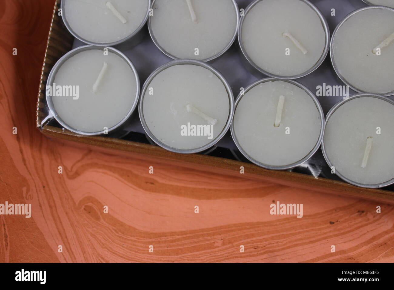 Close up of tea lights packed inside a box kept on handmade paper Stock ...