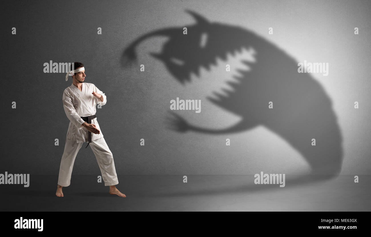 Young karate man fighting with a big black scary shadow Stock Photo - Alamy