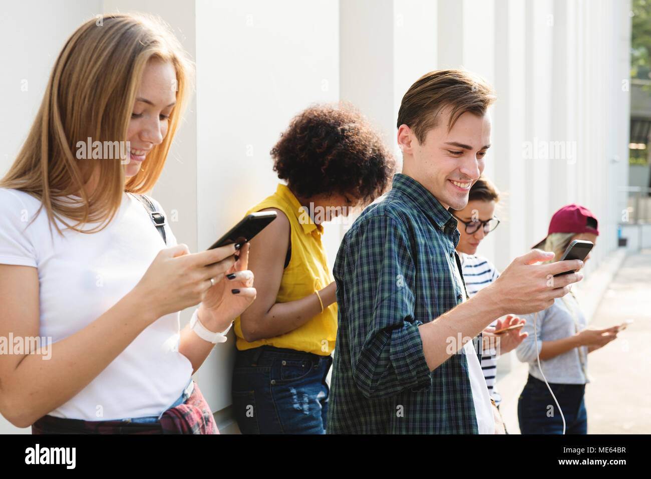 Friends using smartphones outdoors together and chilling Stock Photo ...
