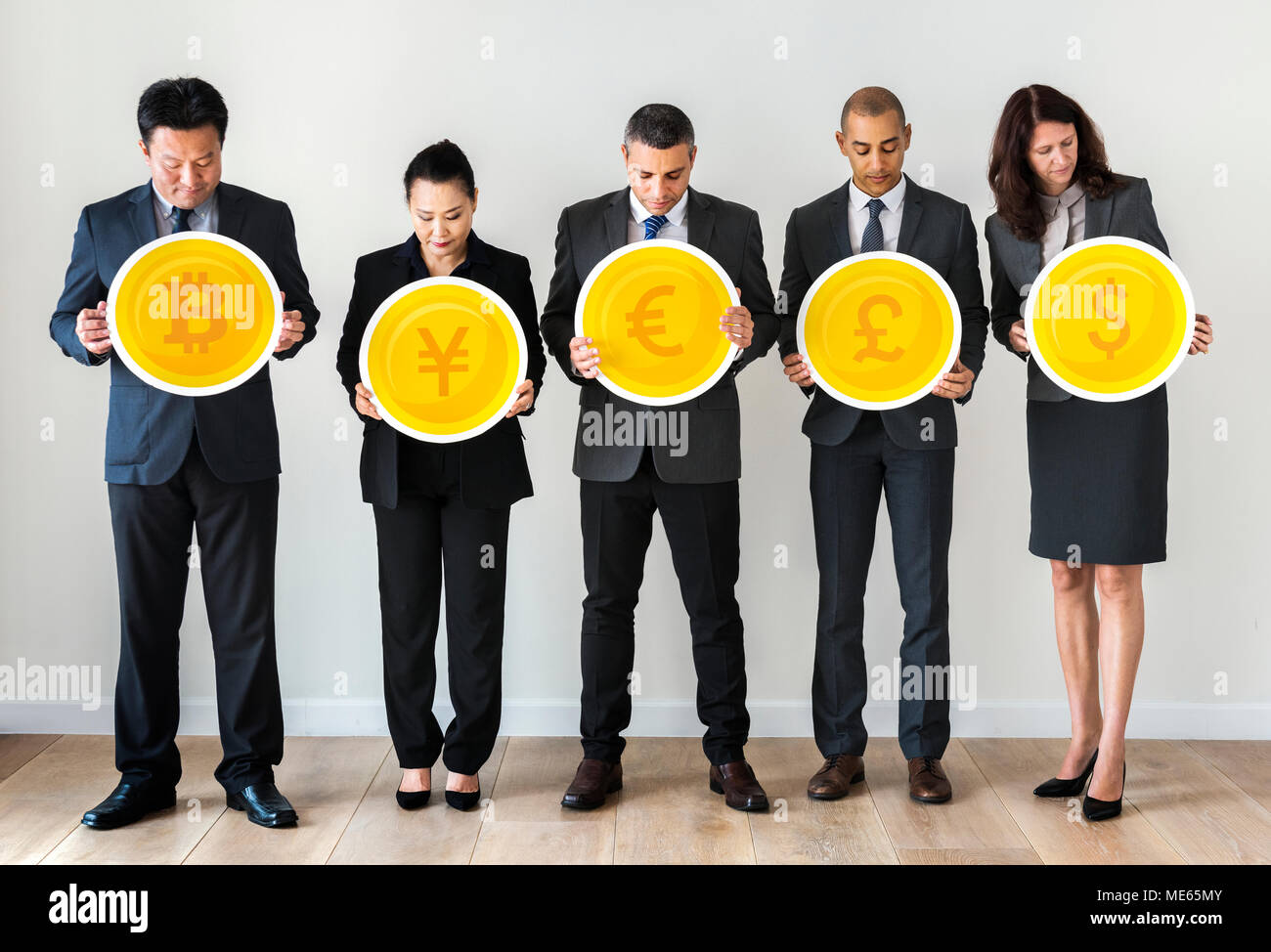 Business people standing and holding currency icons Stock Photo - Alamy
