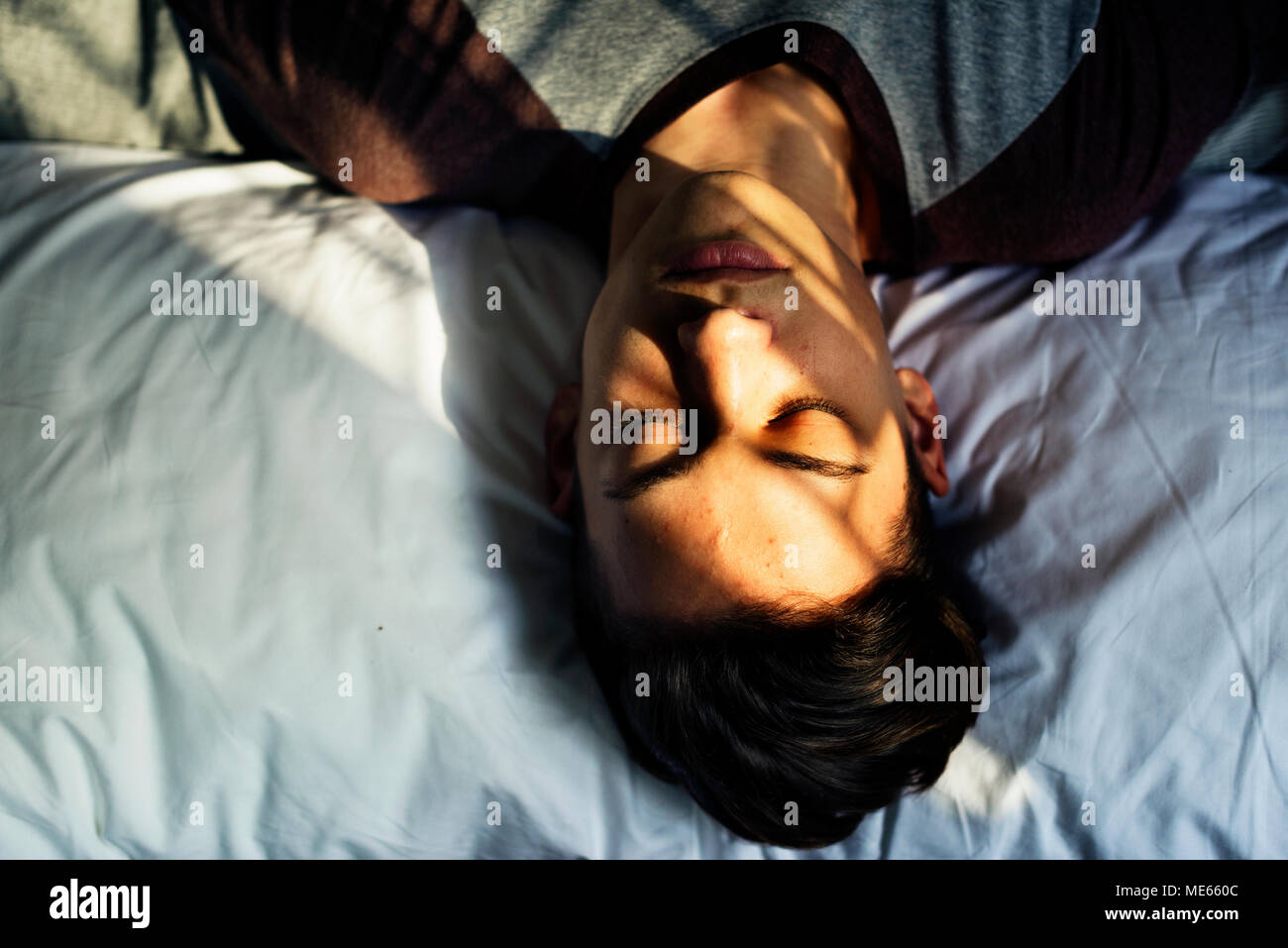 Teenage boy lying down on bed sleepy nap and depression concept Stock ...