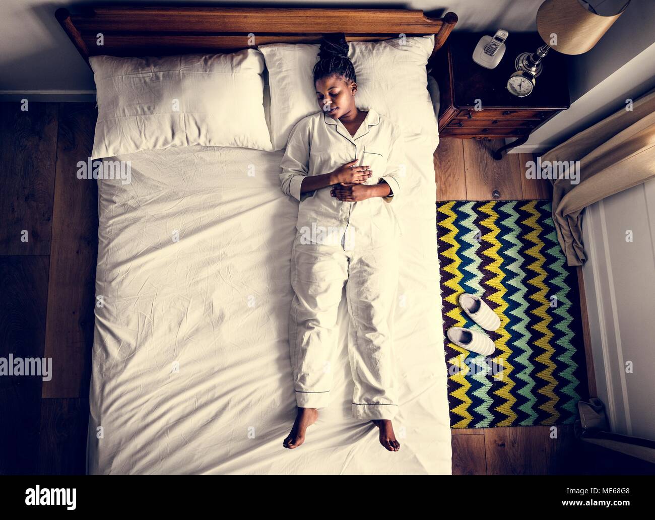 African American woman on bed sleeping alone Stock Photo - Alamy