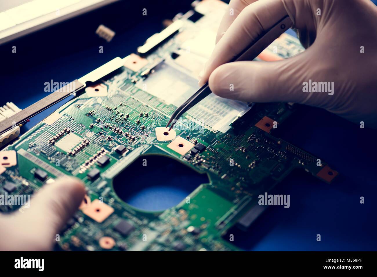 Closeup of hands with computer motherboard and tweezers Stock Photo - Alamy