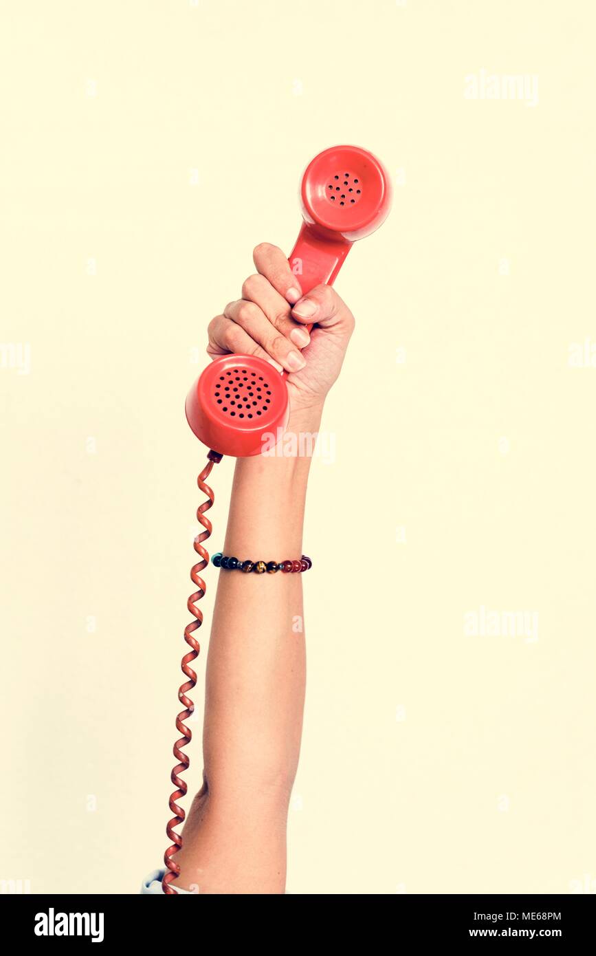 Hand holding red retro telephone isolated on white Stock Photo - Alamy