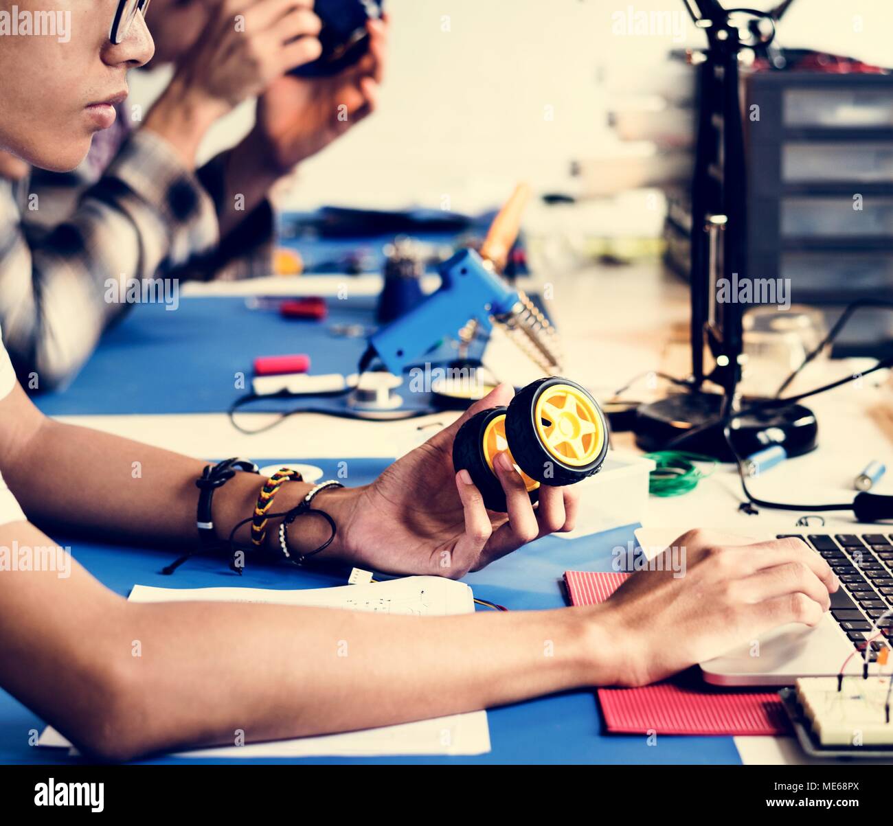 Side view of man working on robot Stock Photo - Alamy