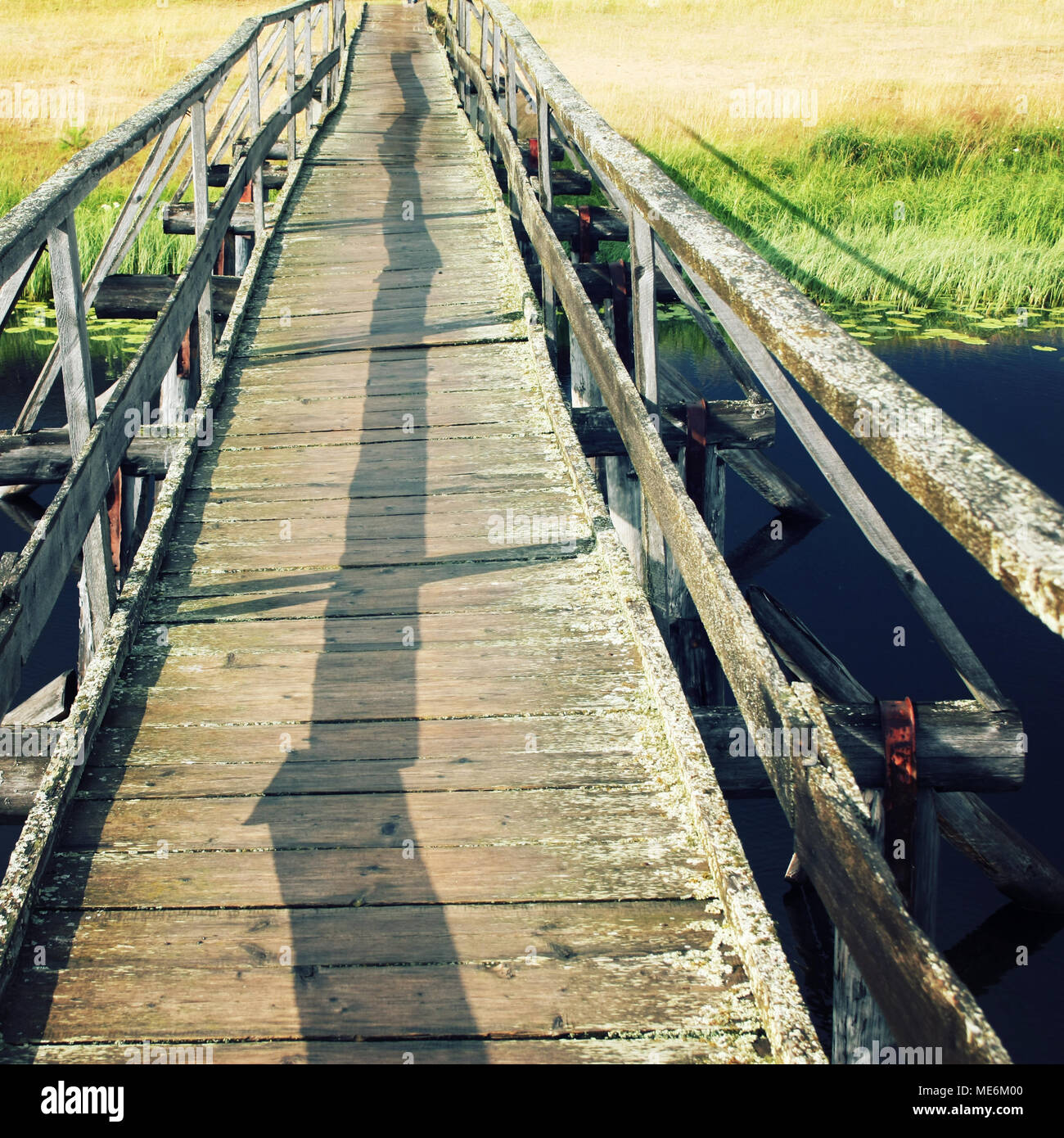 An old wooden bridge. Summer in Russia. Empty walkway. Sunny day. Dark ...