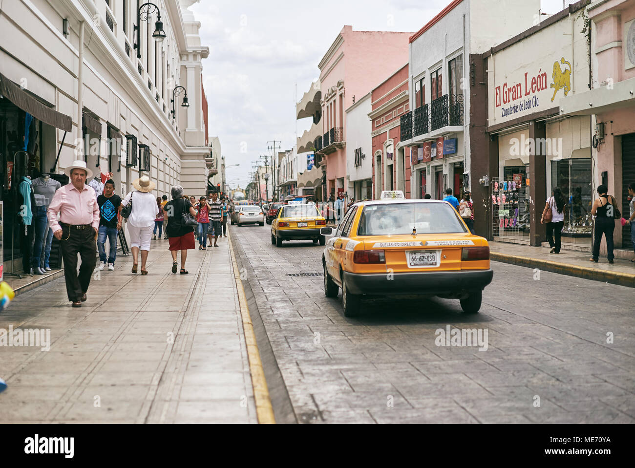 The atmosphere of city center of Merida, people walking, the yellow cab ...