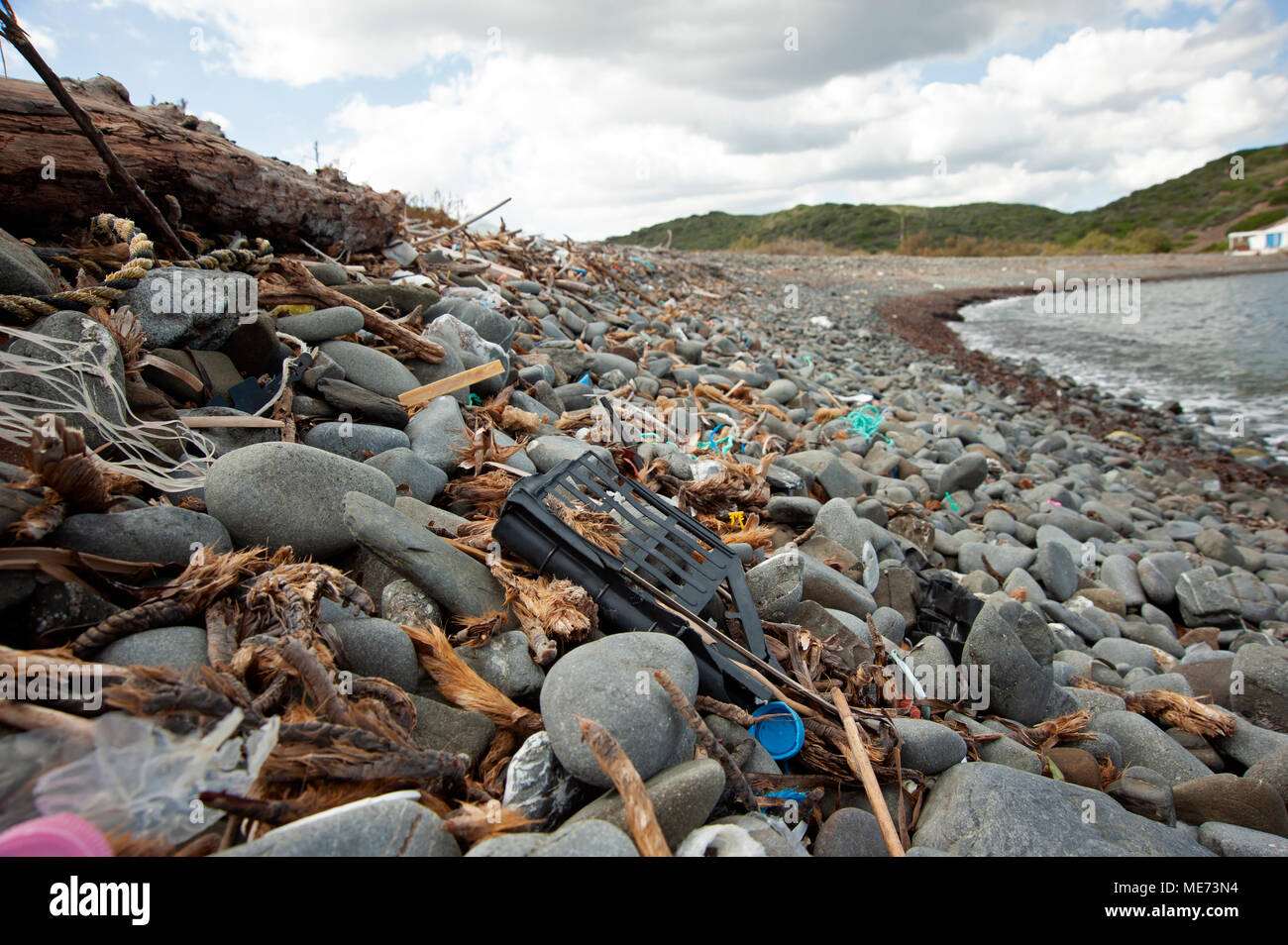 Driftwood and plastic waste washed up on a pebble beach on the northern ...