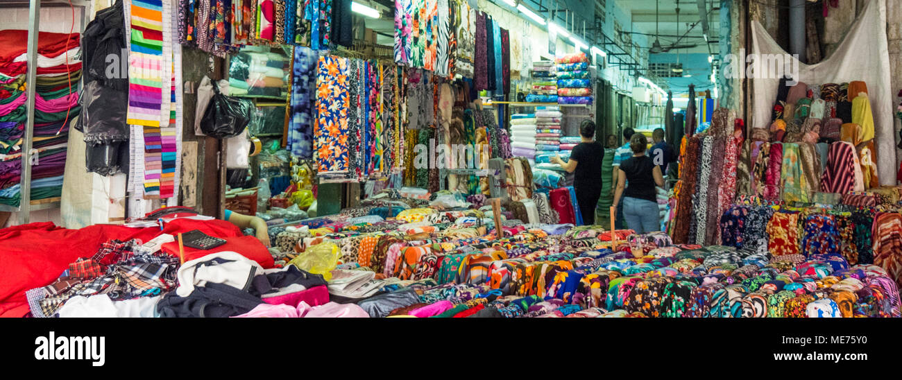 Colourful bolts of cloth on display in stalls in a fabric market in Ho ...