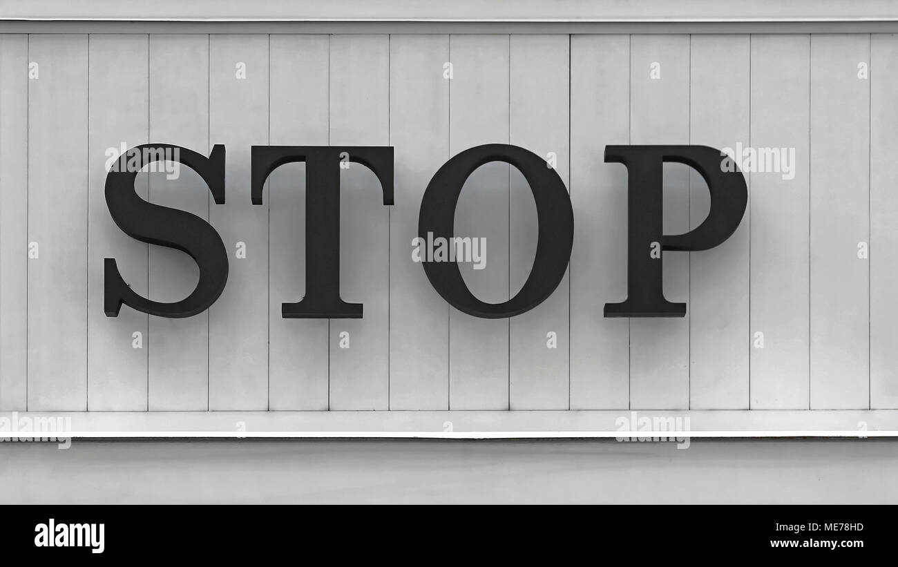 Black Stop Letters Sign at White Wood Board Stock Photo - Alamy
