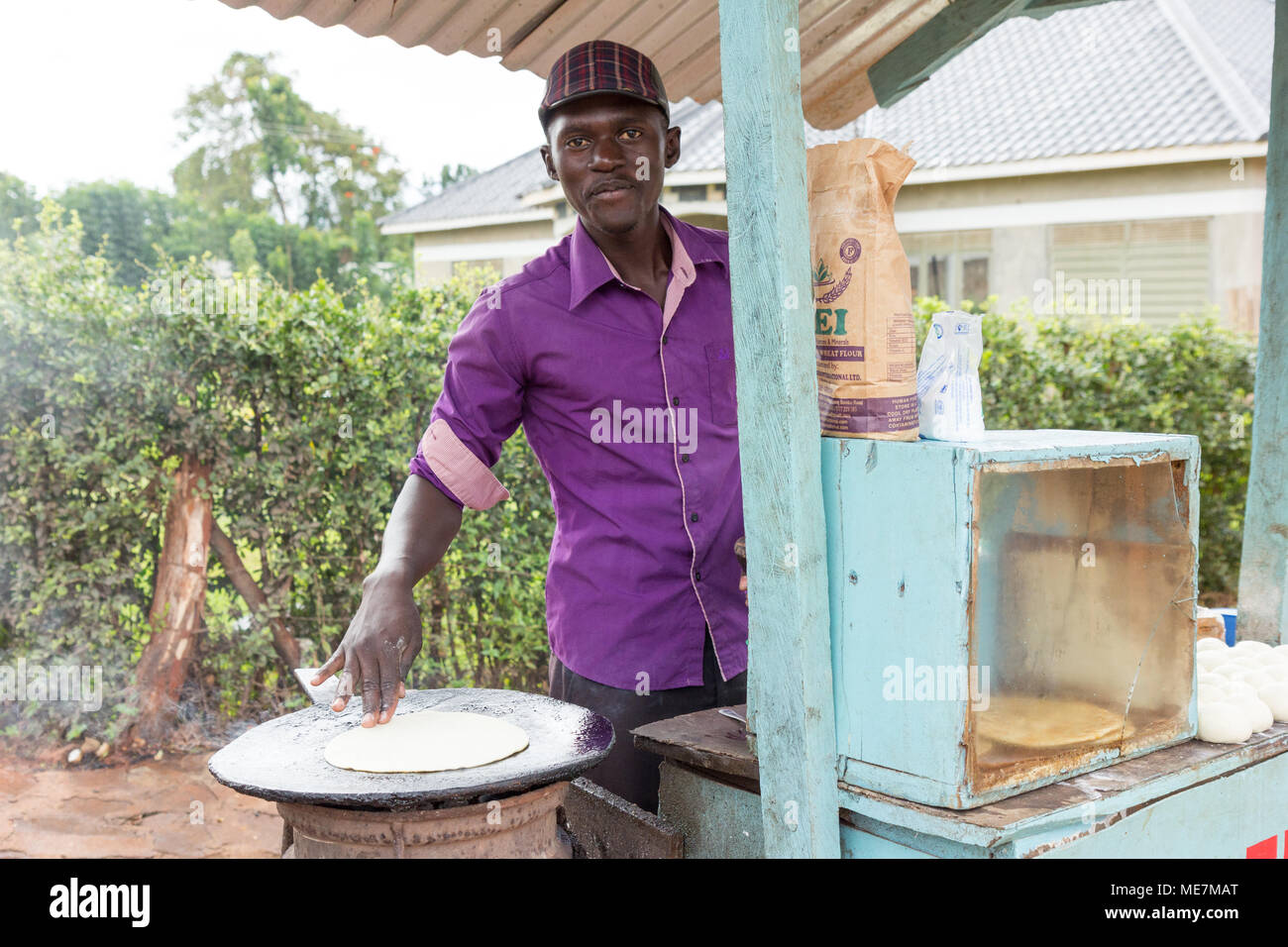 Lugazi, Uganda. 14 May 2017. A young man frying a flatbread called ...