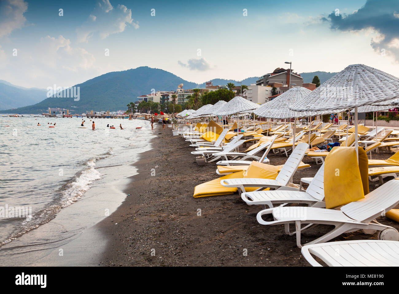 Sunbeds and yellow mattresses on the beach in Marmaris after heavy wind ...