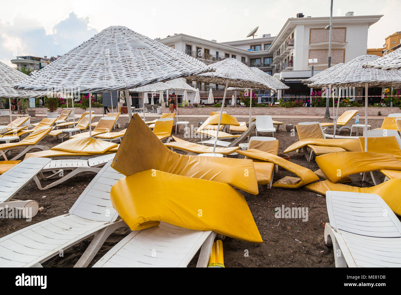 Sunbeds and yellow mattresses on the beach in Marmaris after heavy wind ...