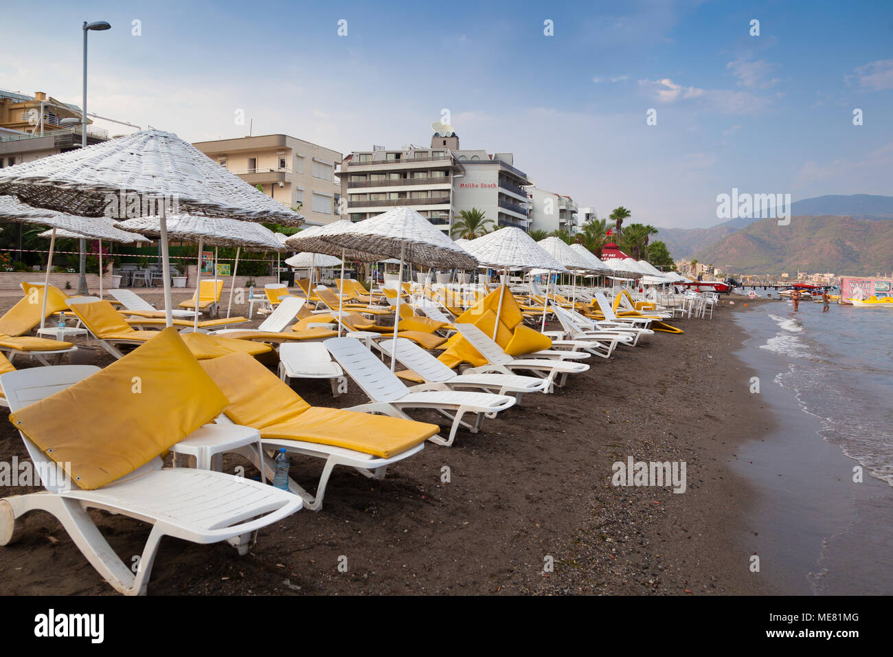Sunbeds and yellow mattresses on the beach in Marmaris after heavy wind ...