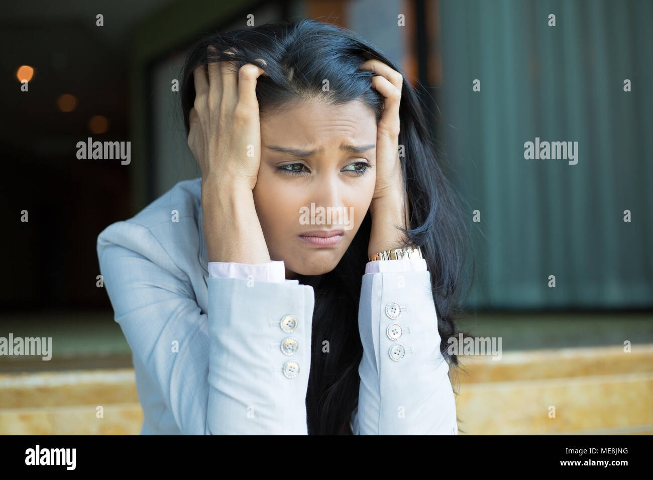 Closeup portrait, sad young woman in white gray suit sitting on stairs ... Closeup portrait, sad young woman in white gray suit sitting on stairs ...