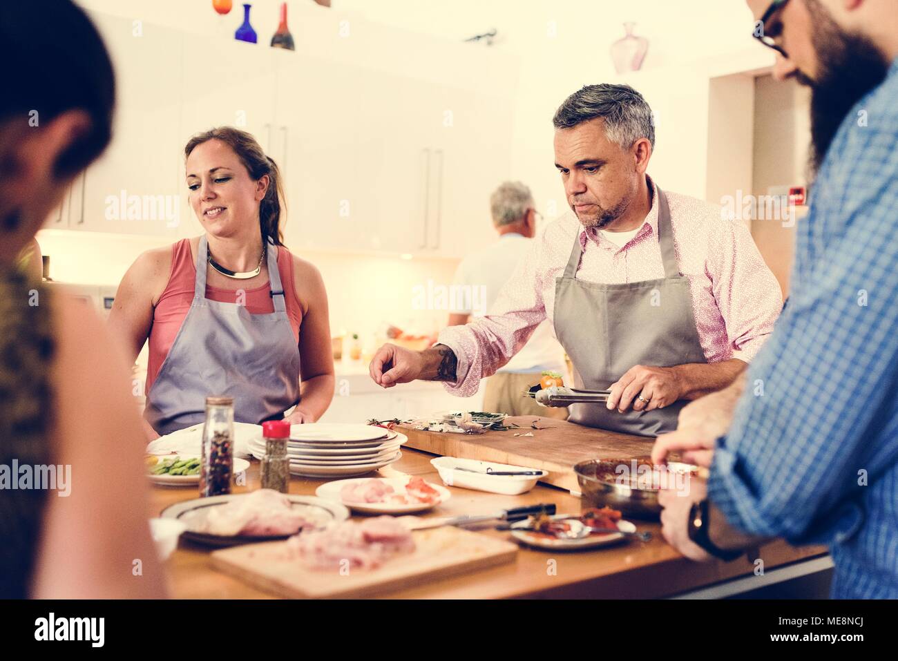 Group of friends are cooking in the kitchen Stock Photo - Alamy